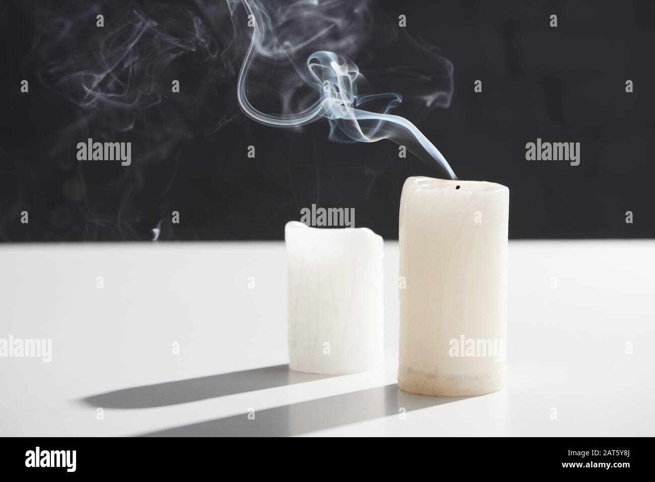 extinct white candles with smoke on black background Stock Photo - Alamy