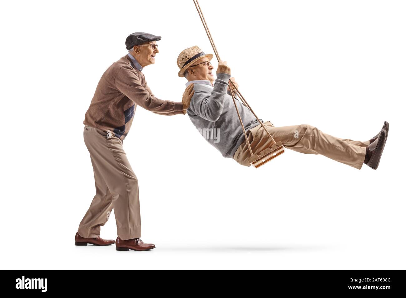 Full length profile shot of senior man pushing his friend on a swing ...