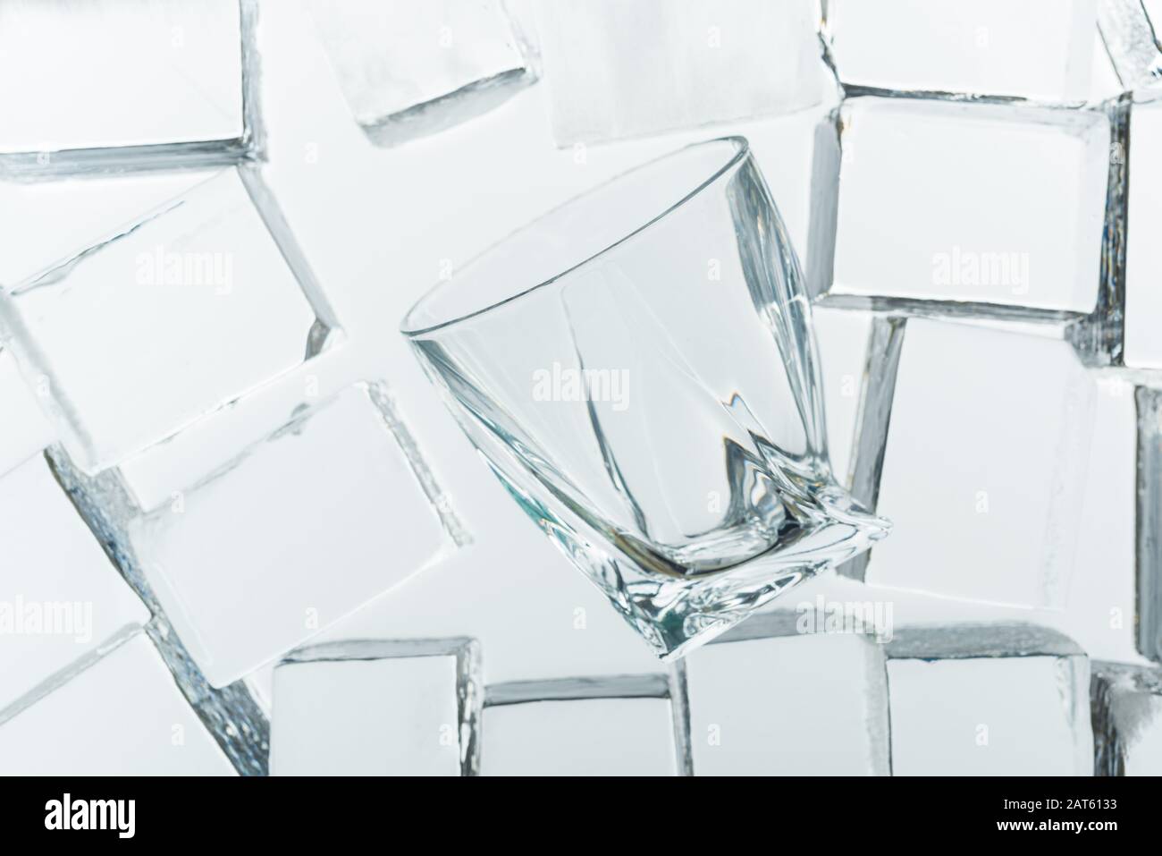top view of transparent clear square ice cubes and empty glass on ...