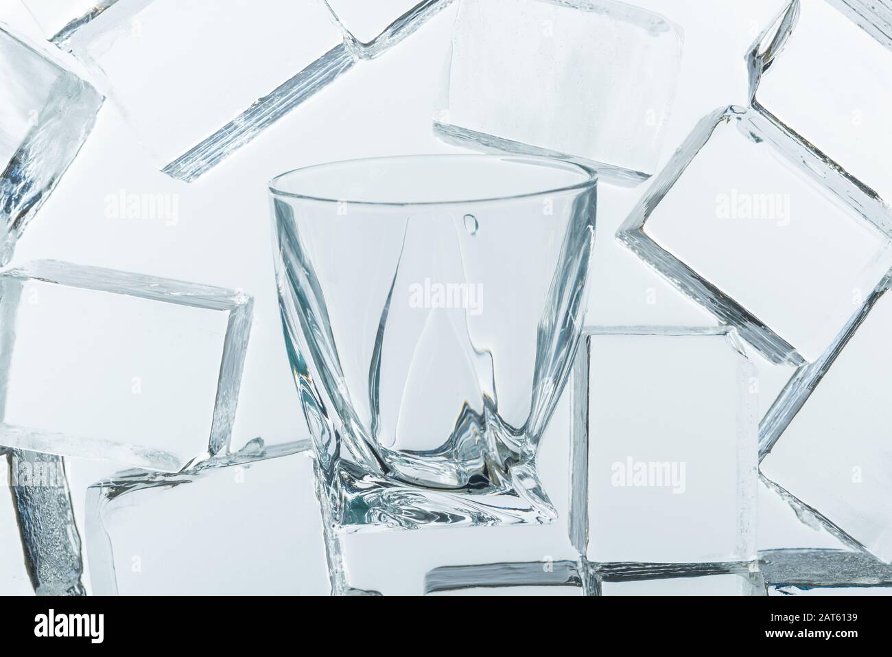 top view of transparent clear square ice cubes and empty glass on ...