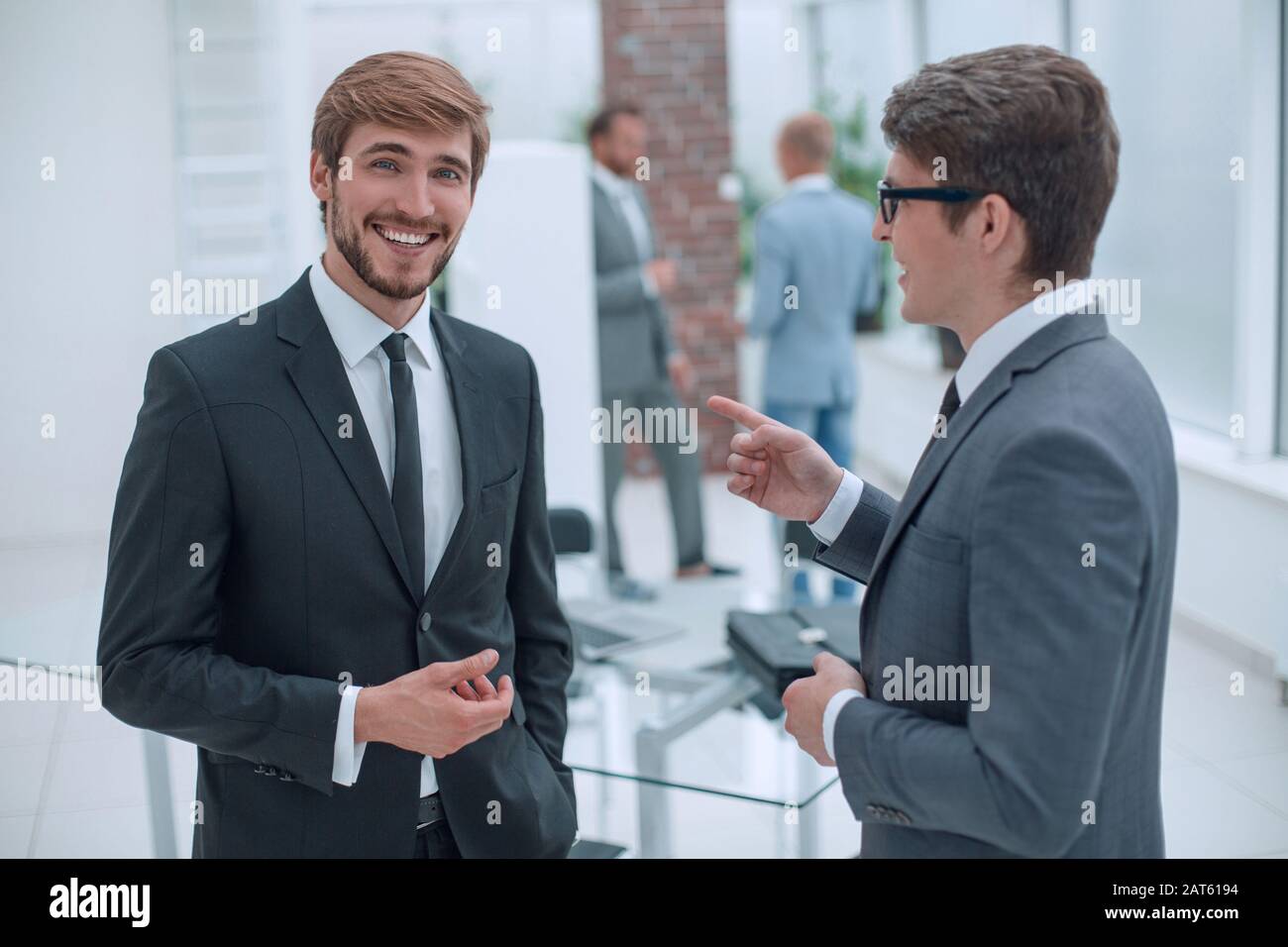 Employees discuss ideas standing hi-res stock photography and images ...