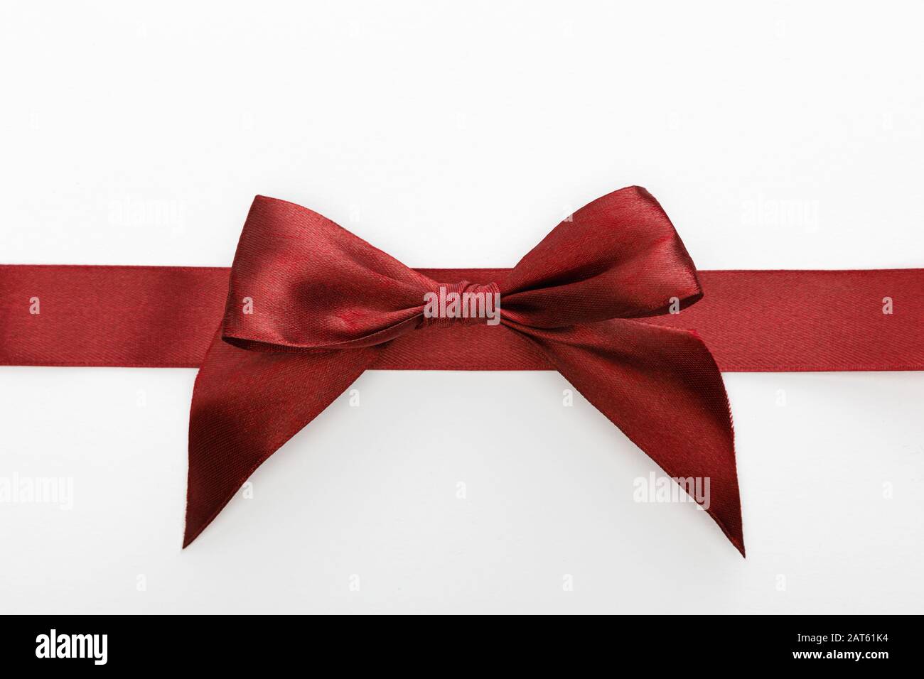 top view of satin burgundy decorative ribbon with bow isolated on white ...
