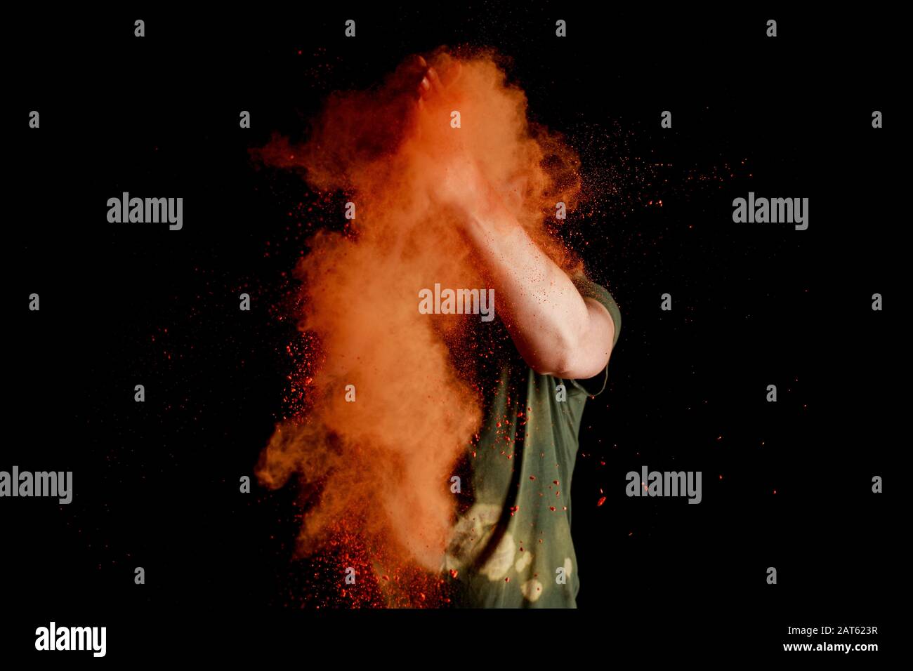 woman with orange colorful holi paint explosion in front of face on ...