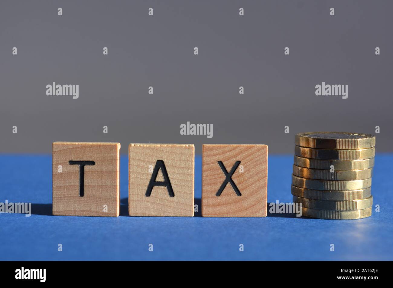 Stack of coins and the word Tax, with copy space Stock Photo - Alamy