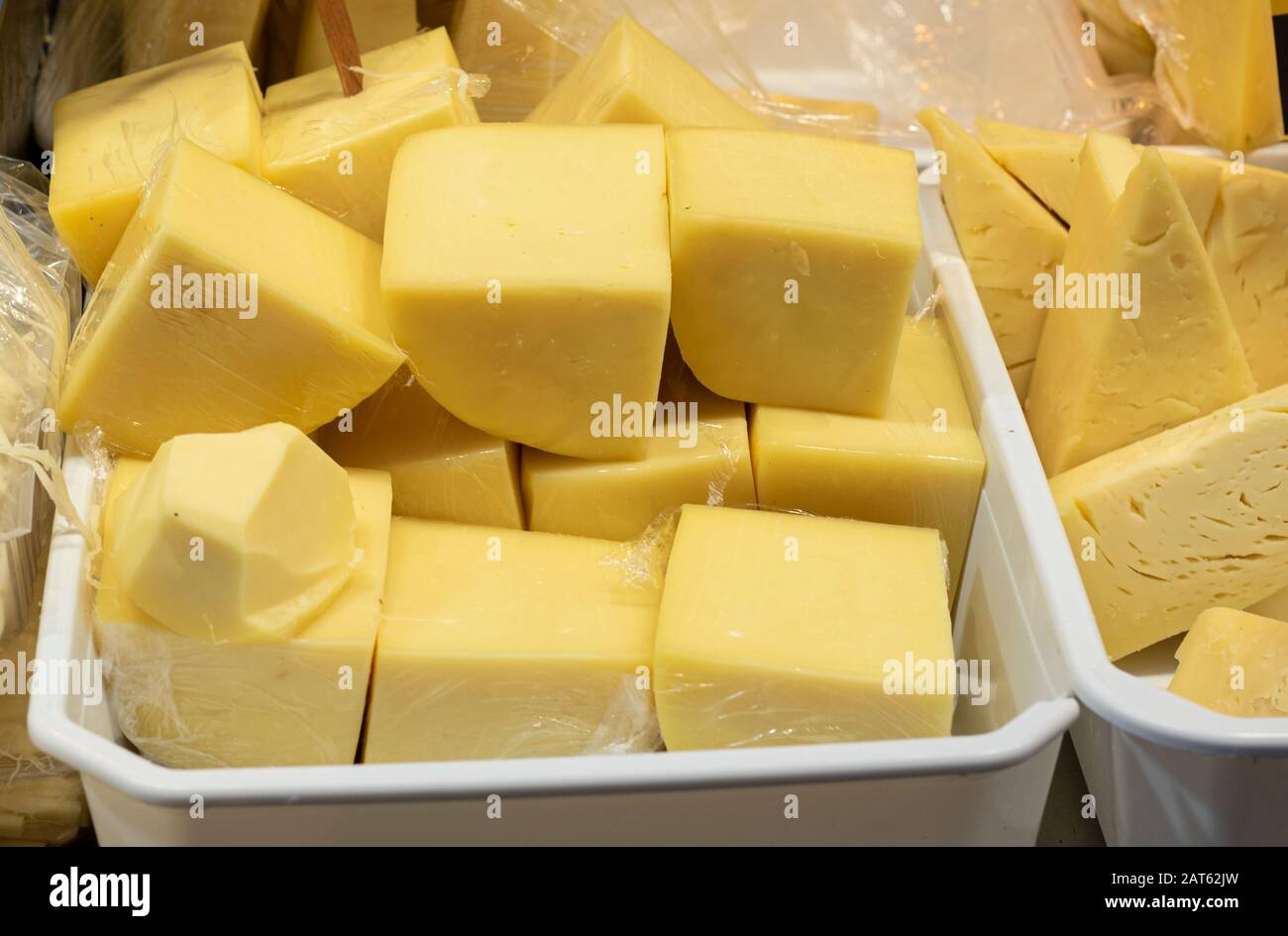 Close-up of cheddar cheese is sold in the market. Triangular slice ...