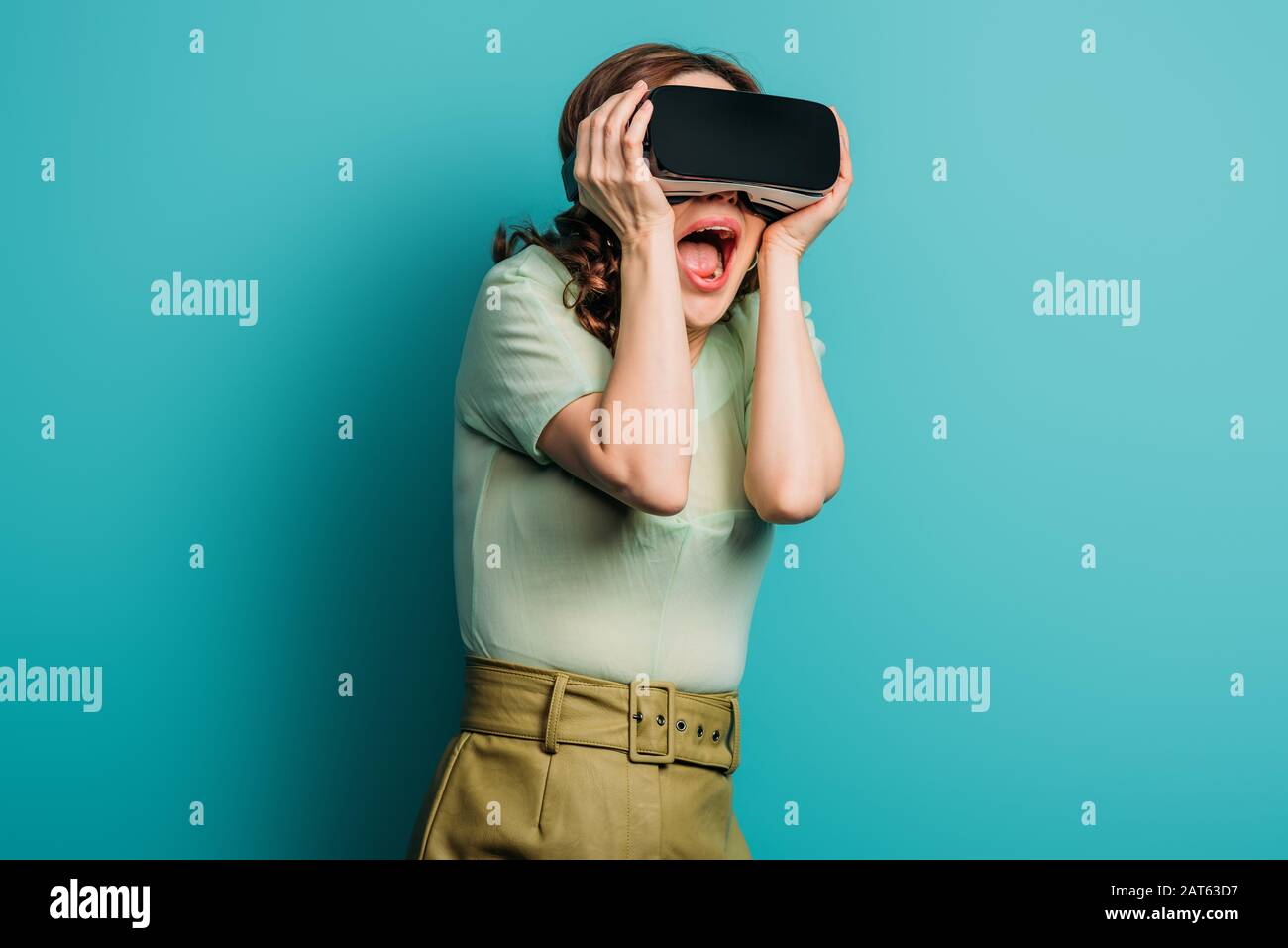 scared girl in vr headset touching head and screaming on blue ...