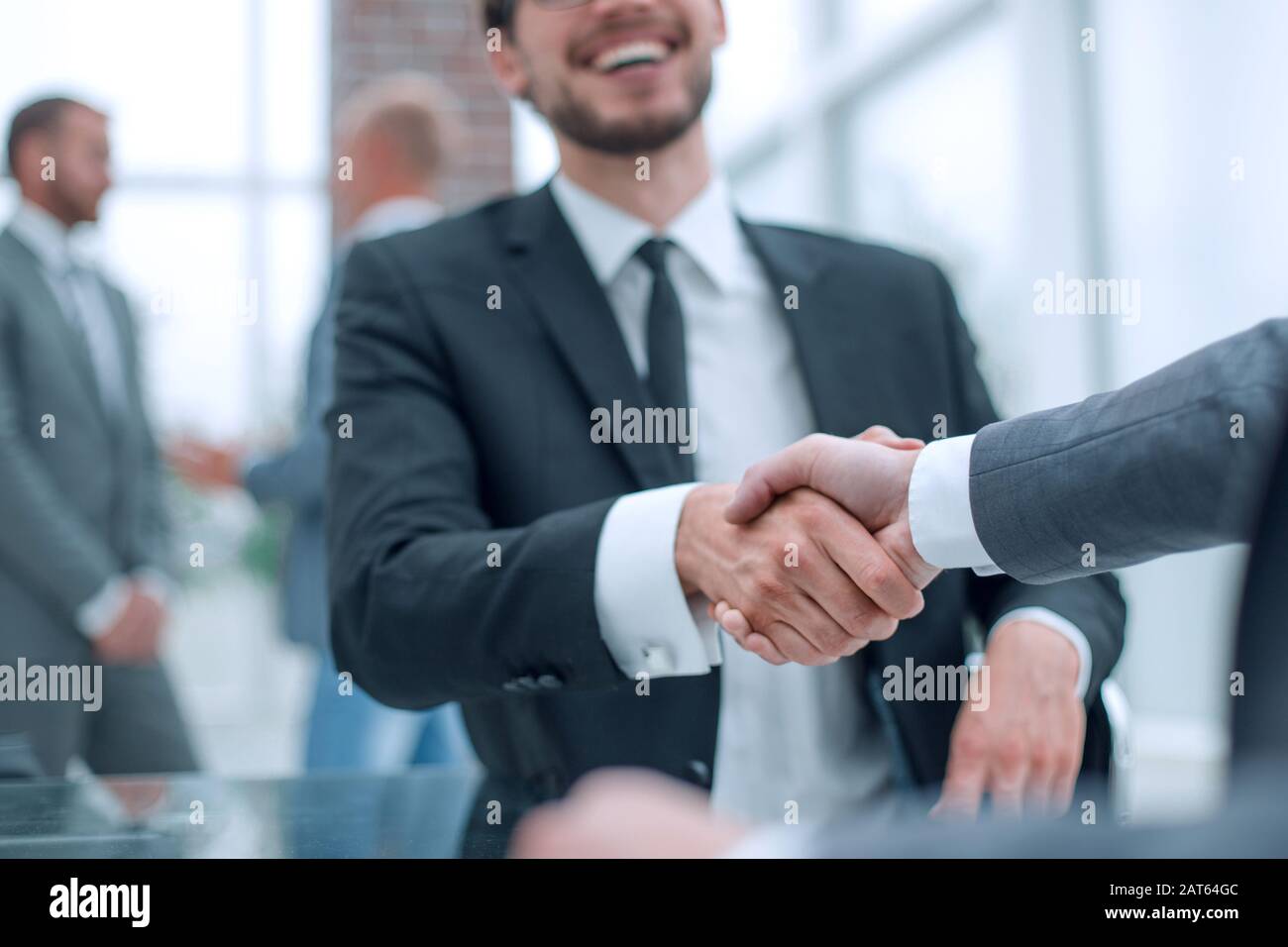 happy business partners shaking hands at the negotiating table Stock ...