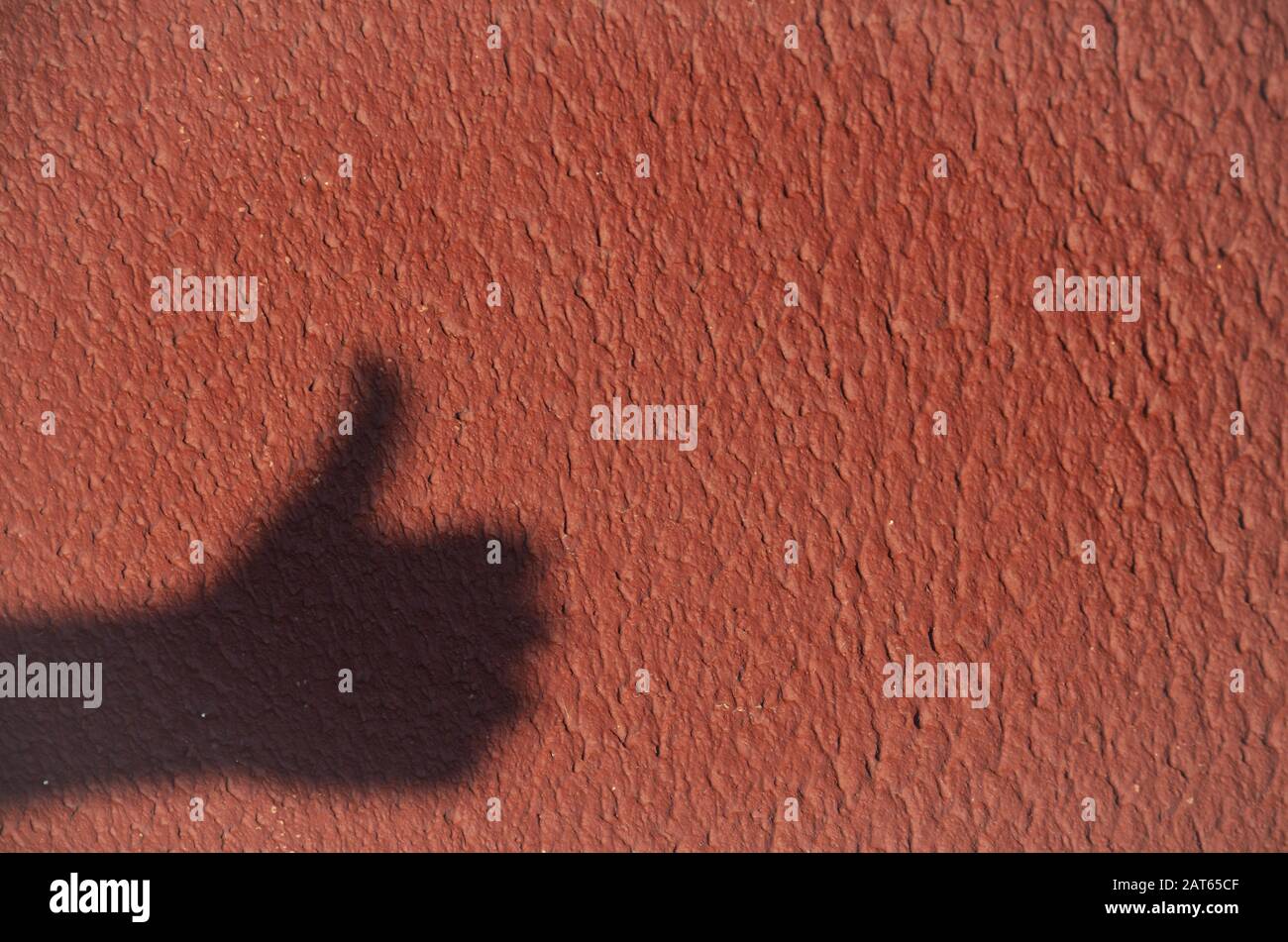 Against the red wall shadow where the thumbs up gesture is all right ...