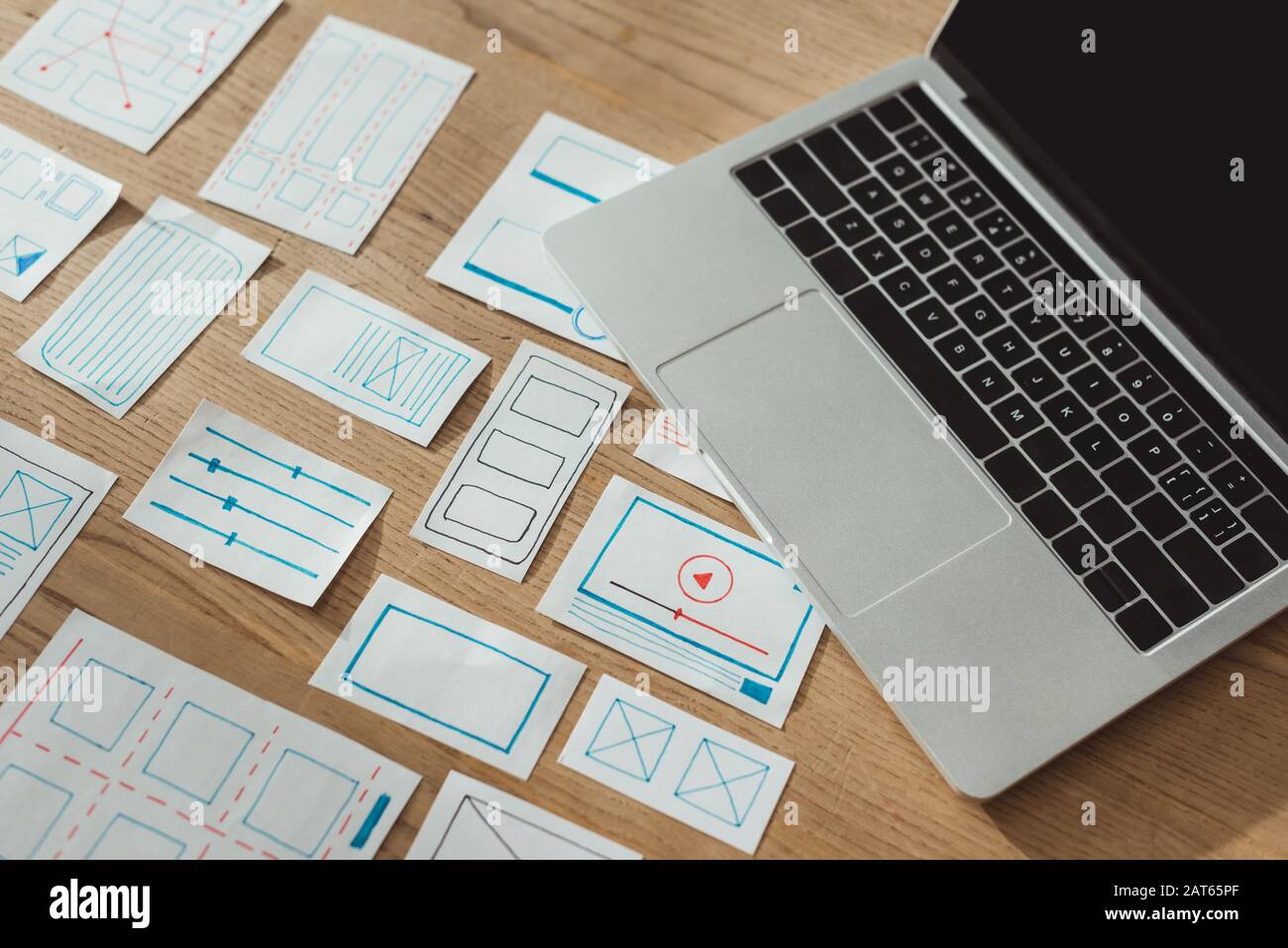 High angle view of ux app development sketches and laptop on wooden ...