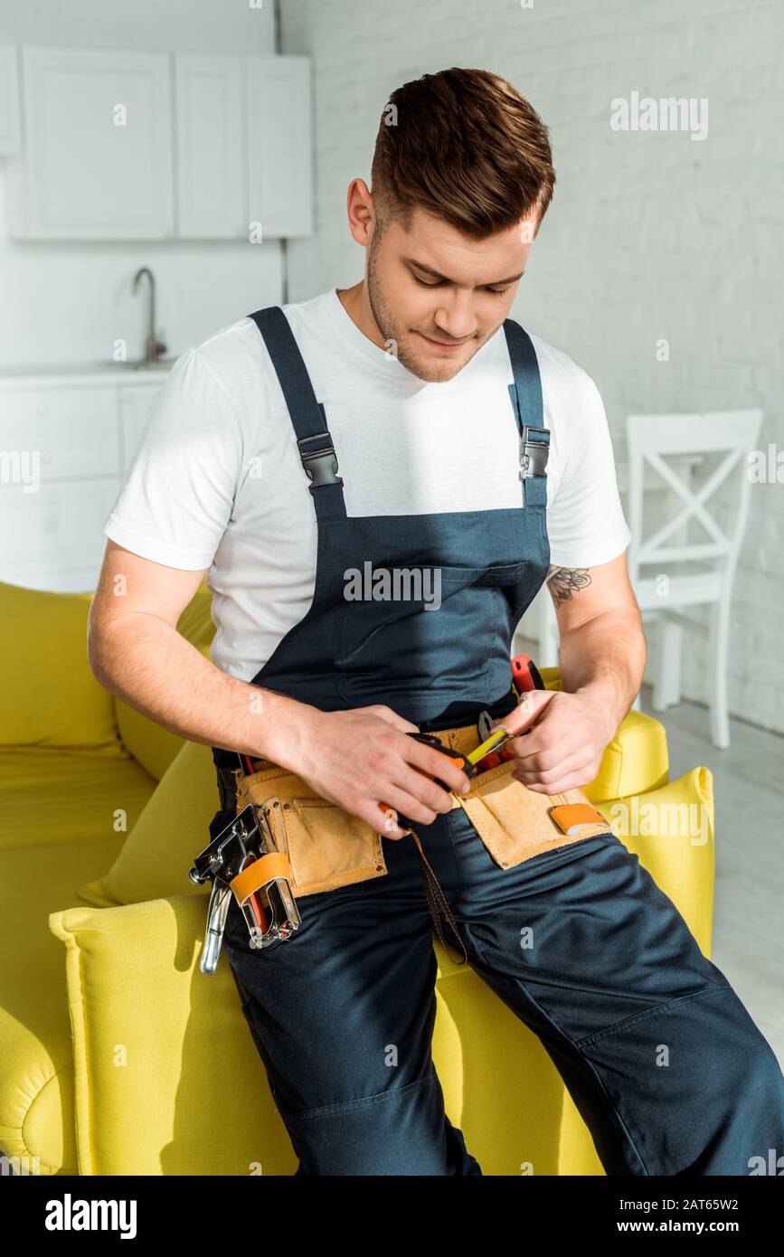 sunshine on handsome installer in overalls holding measuring tape Stock ...