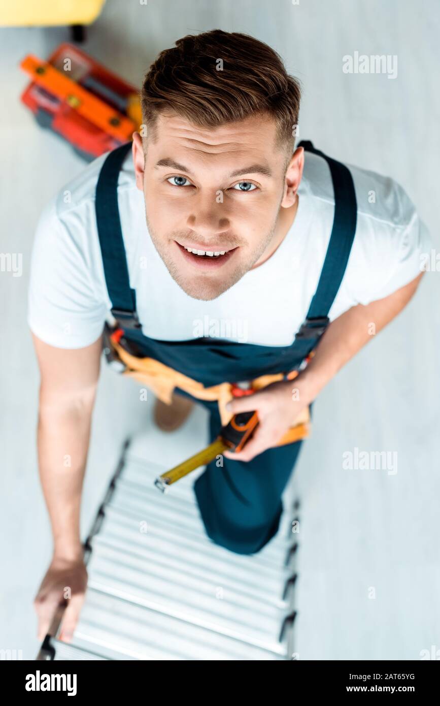top view of happy installer climbing ladder and looking at camera Stock ...