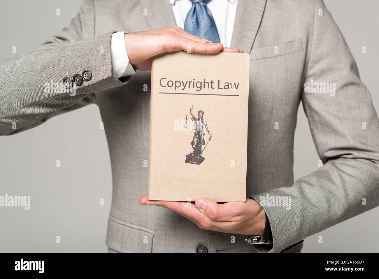 cropped view of lawyer holding book with copyright law title isolated ...