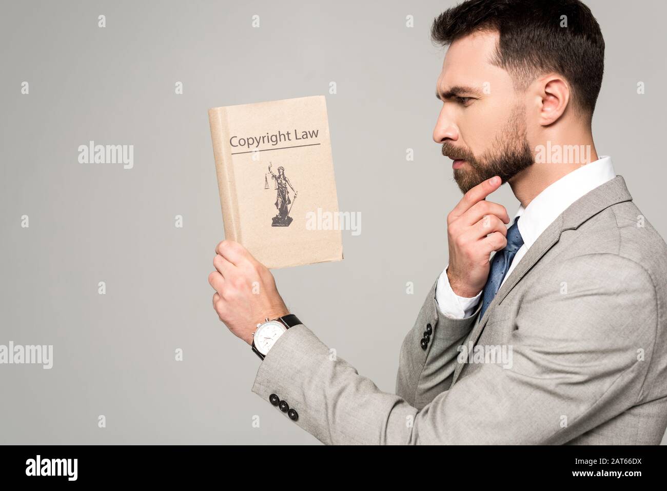 side view of serious lawyer reading book with copyright law title ...