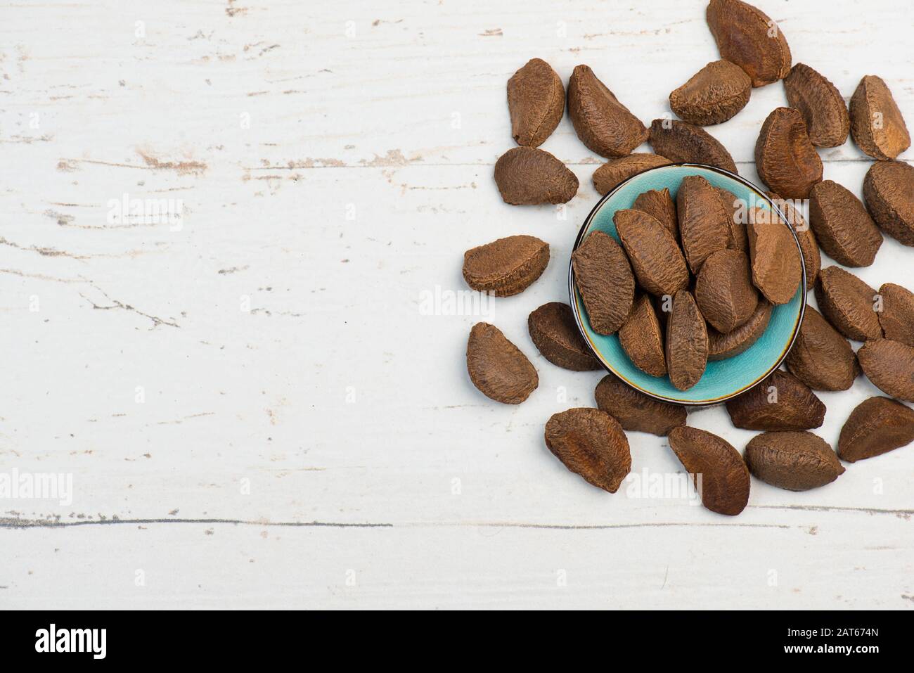 Pecan nuts in the nutshell on a white textured backgropund, empty copy ...