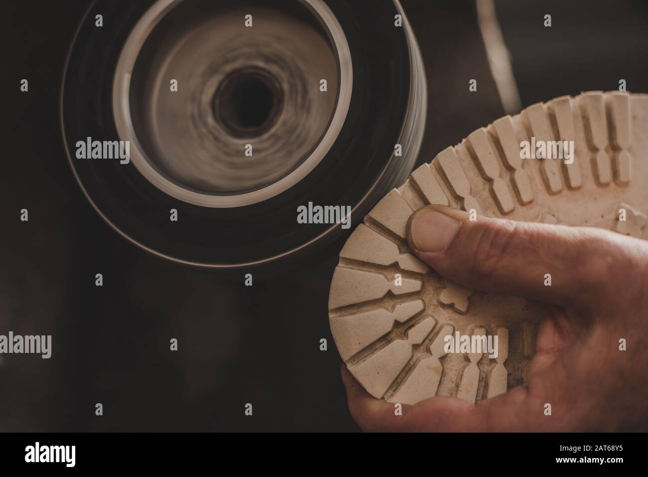 partial view of shoemaker polishing shoe sole on grinding machine Stock ...