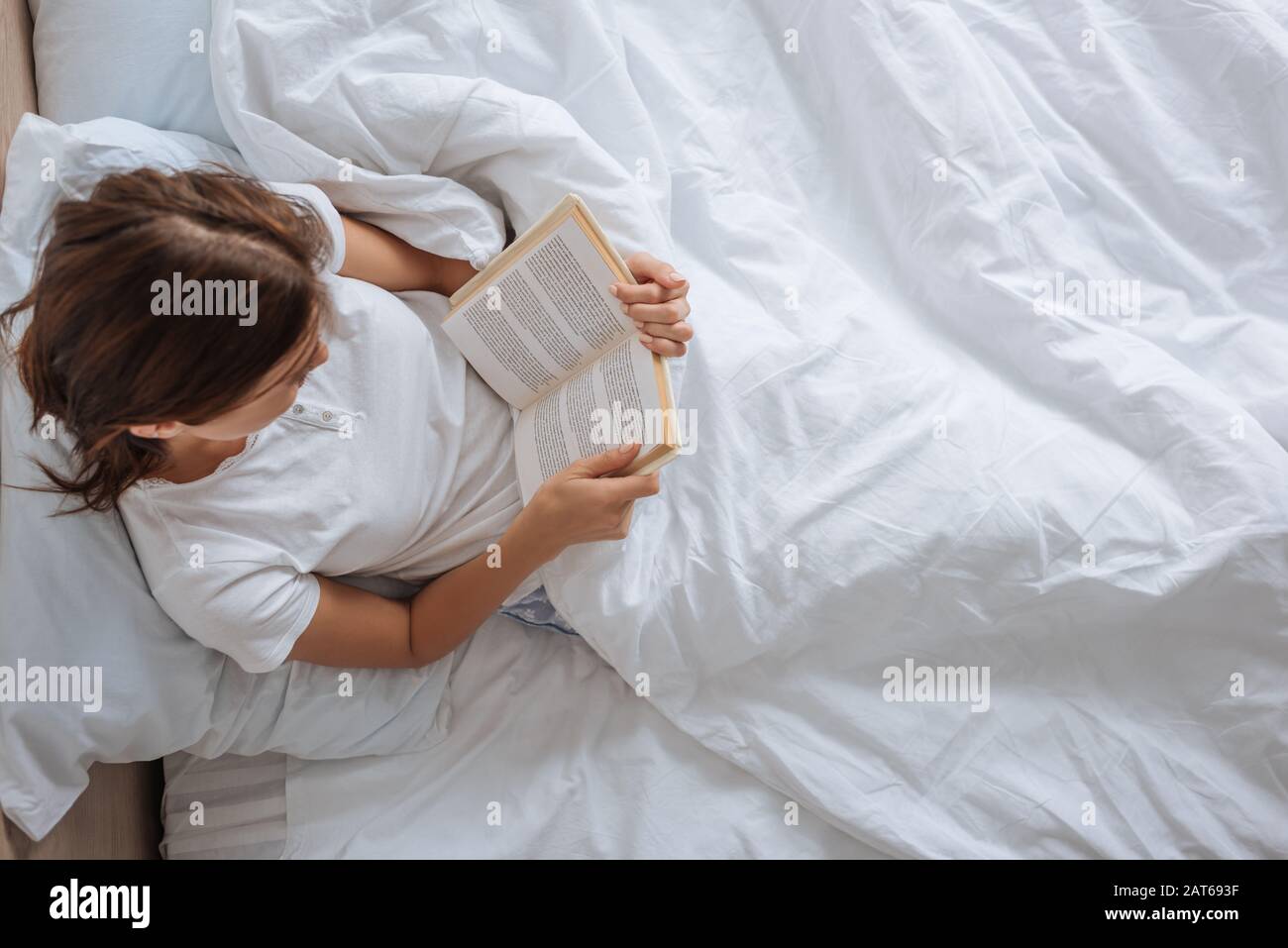 top view of girl reading book while chilling in bed Stock Photo - Alamy