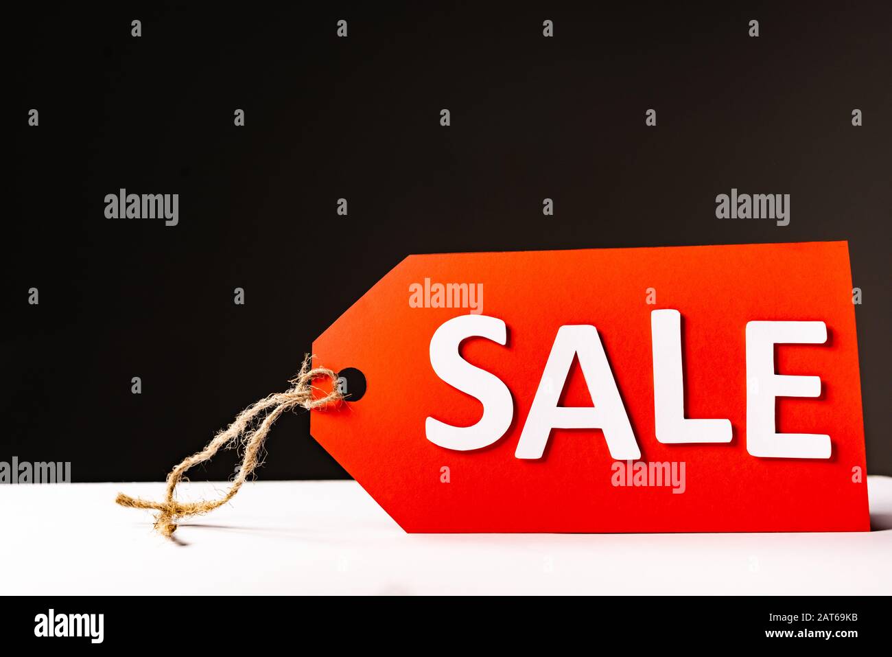 red price tag with sale lettering isolated on black Stock Photo - Alamy