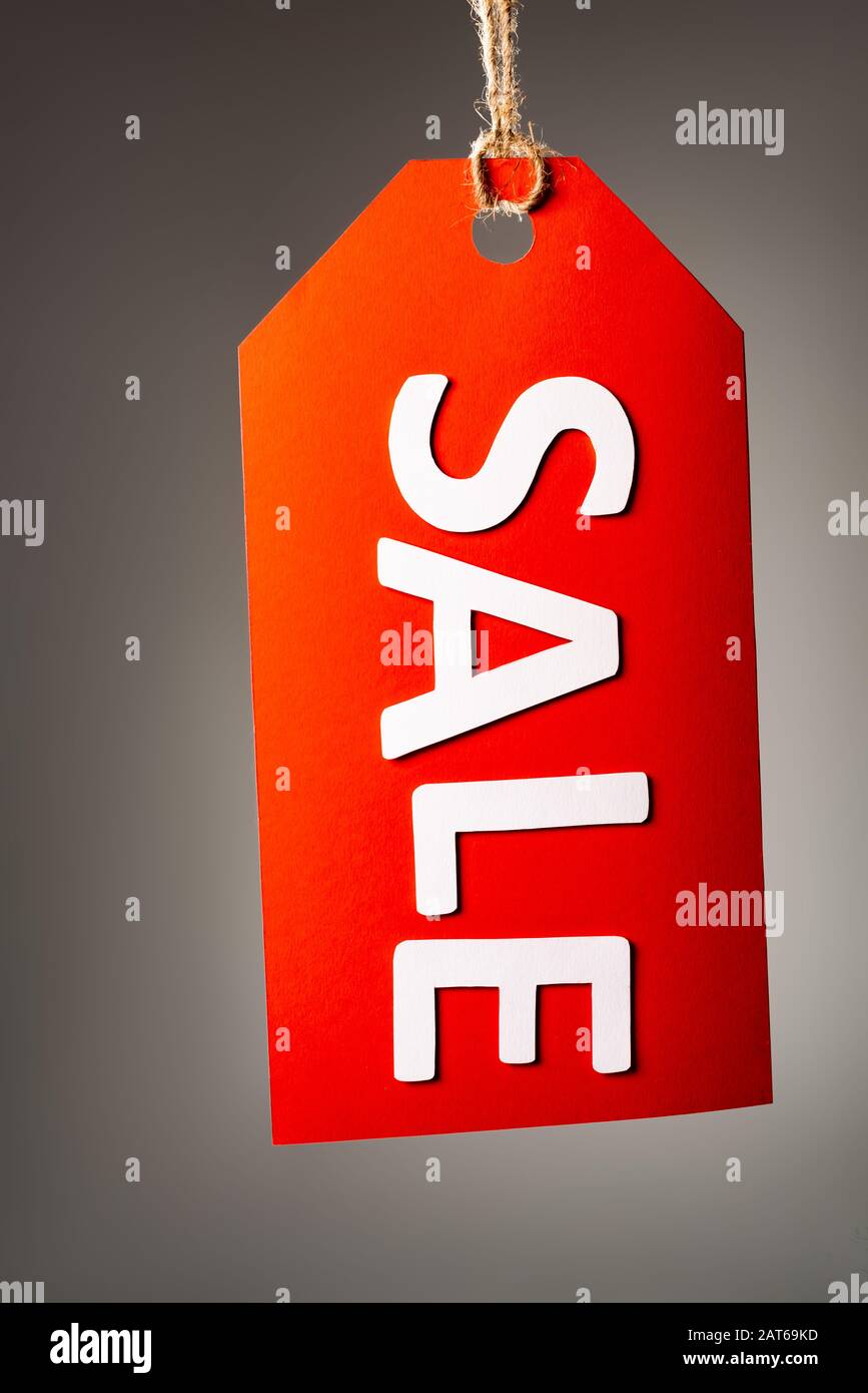 red price tag with sale lettering on black background Stock Photo - Alamy
