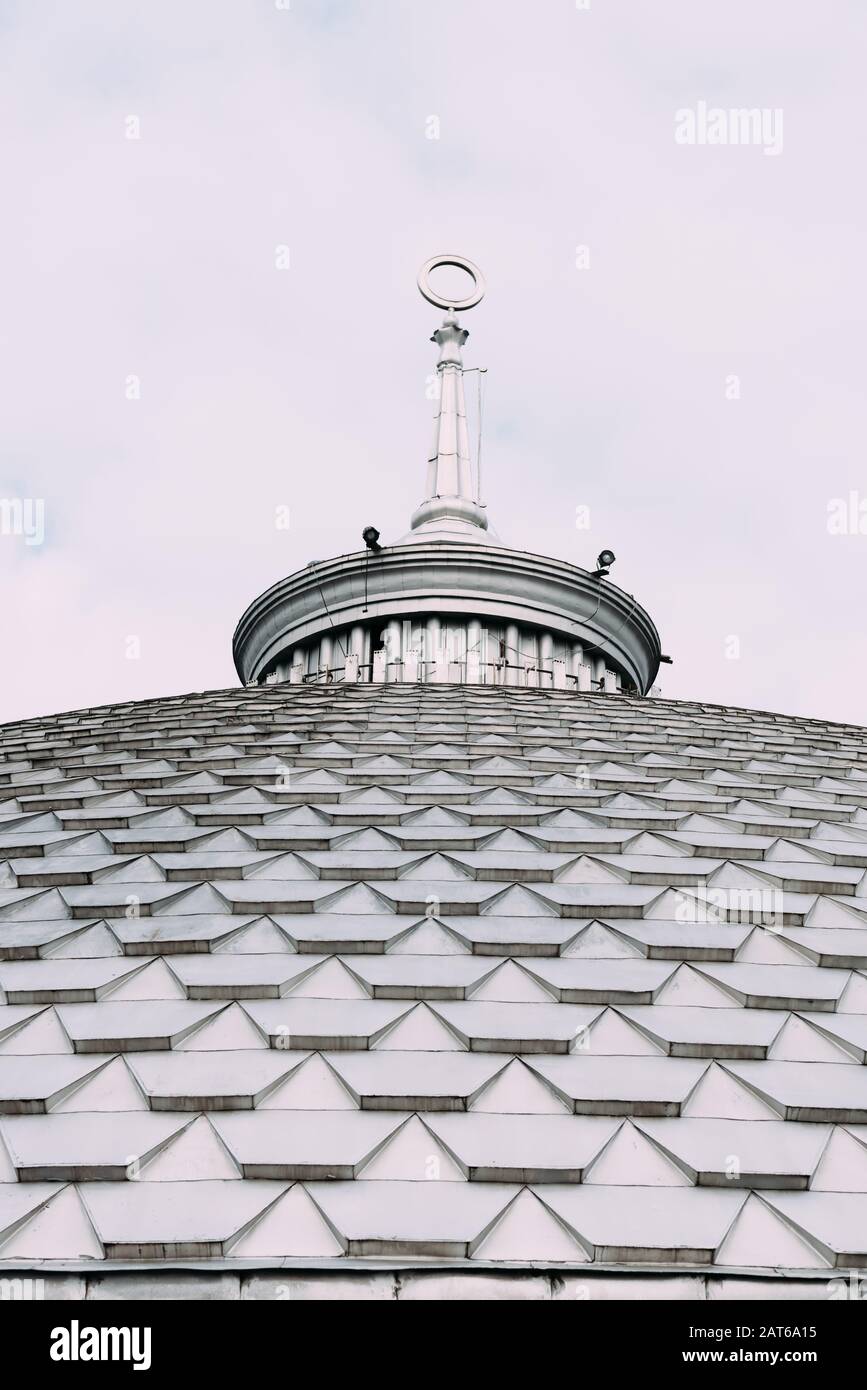 Low angle view of spire on roof of building with cloudy sky at ...