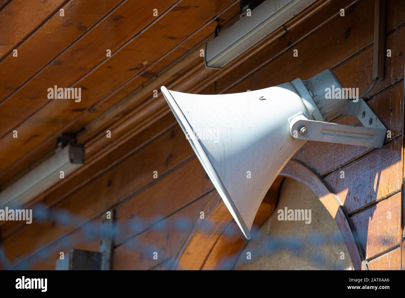 White megaphone hanging on a wood wall Stock Photo - Alamy