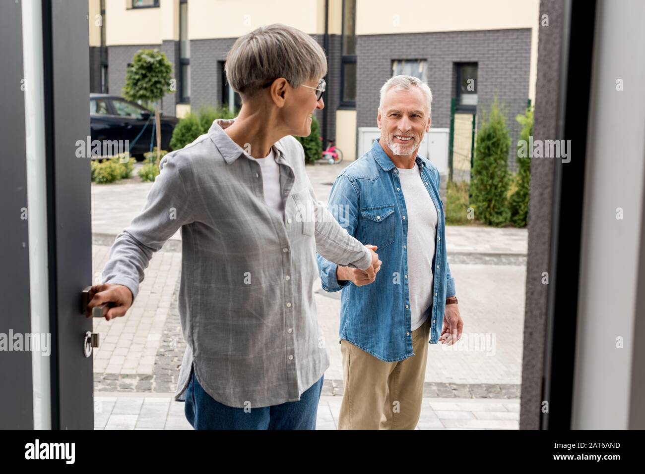 woman holding hands with man and entering to new house Stock Photo - Alamy