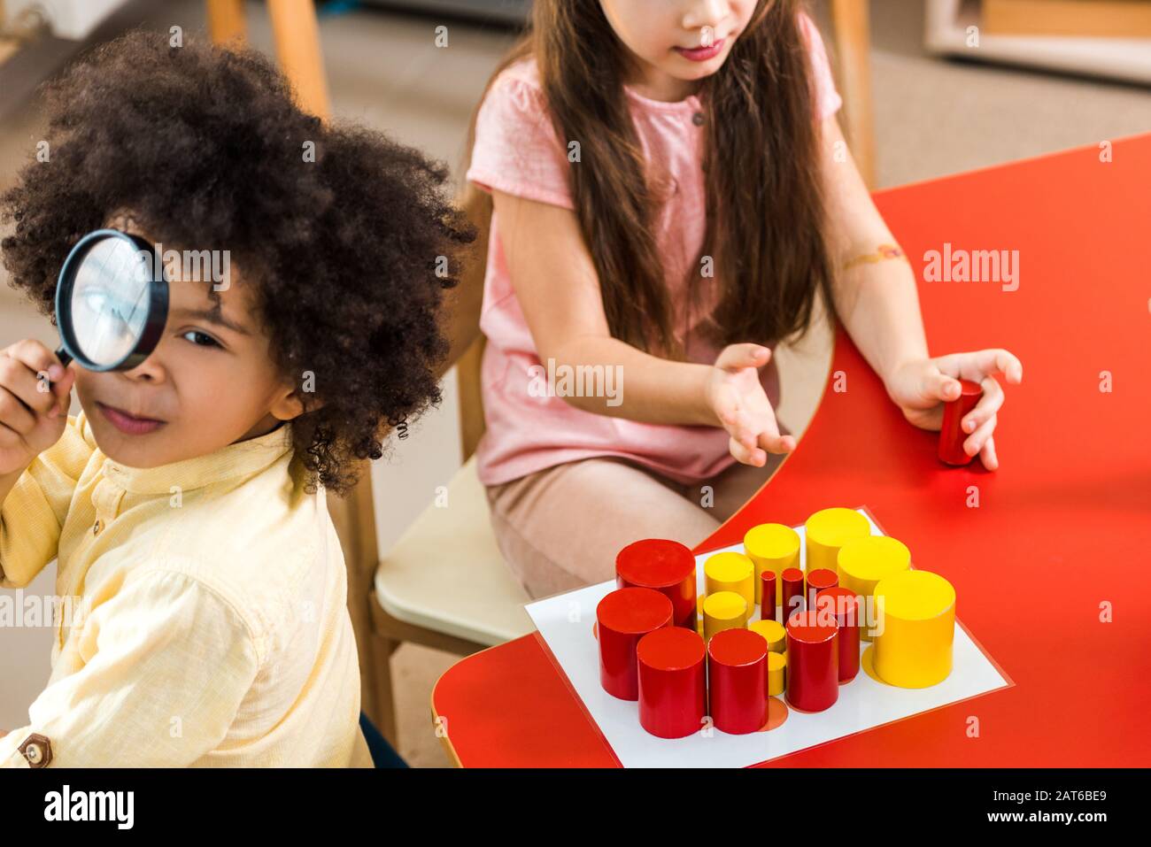 High angle view of kids with educational game and magnifying glass in ...