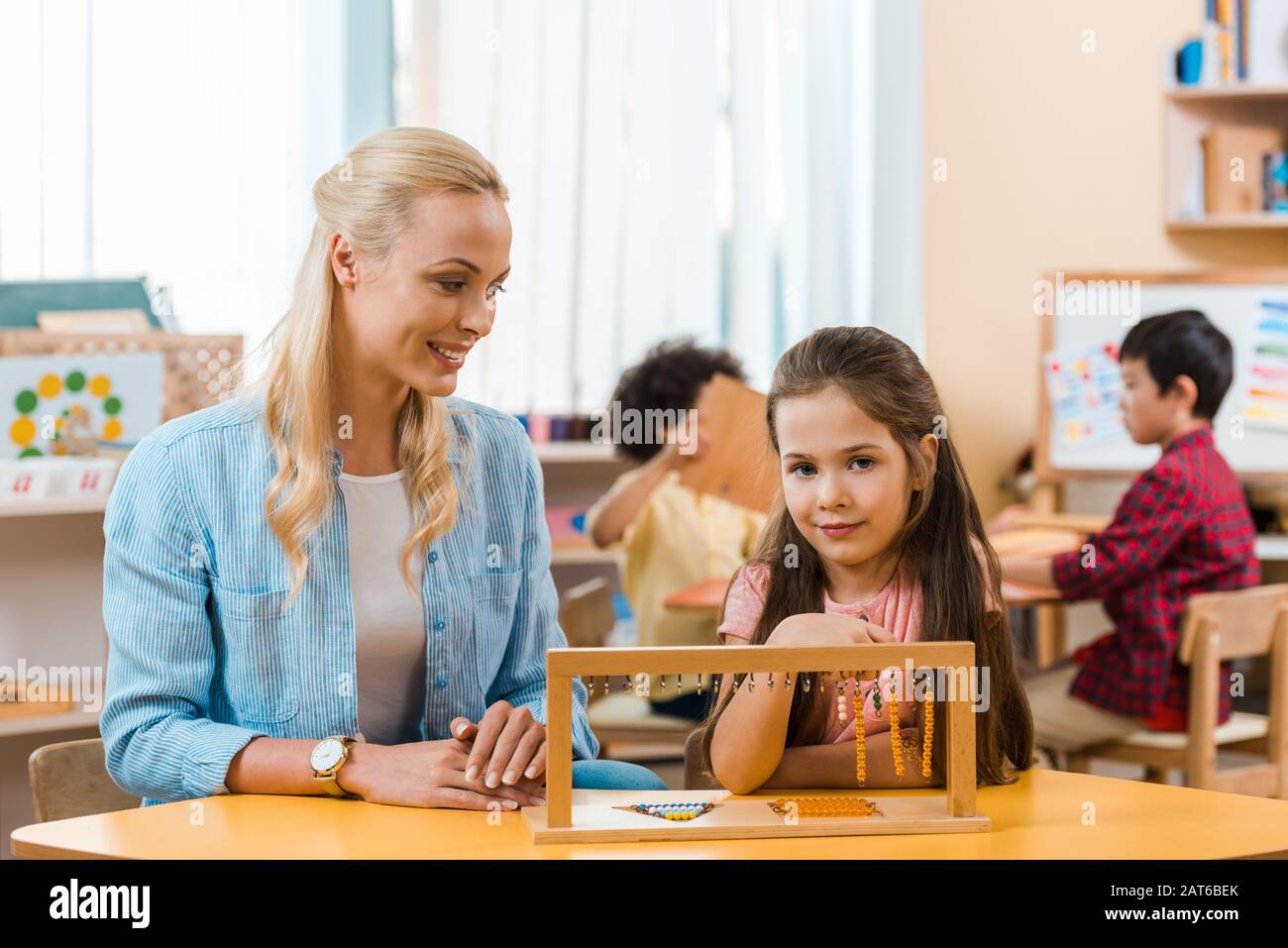 Smiling child looking at camera while playing educational game by ...
