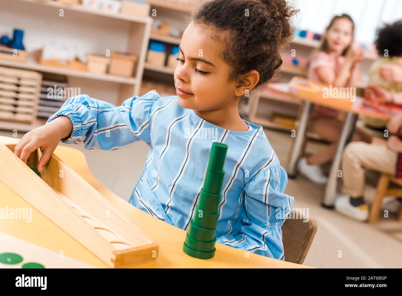 Selective focus of child playing educational game with kids at ...
