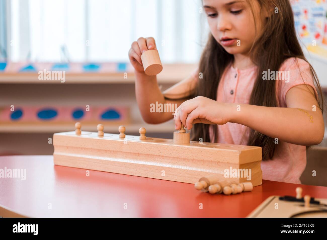 Child playing wooden educational game in montessori school Stock Photo ...