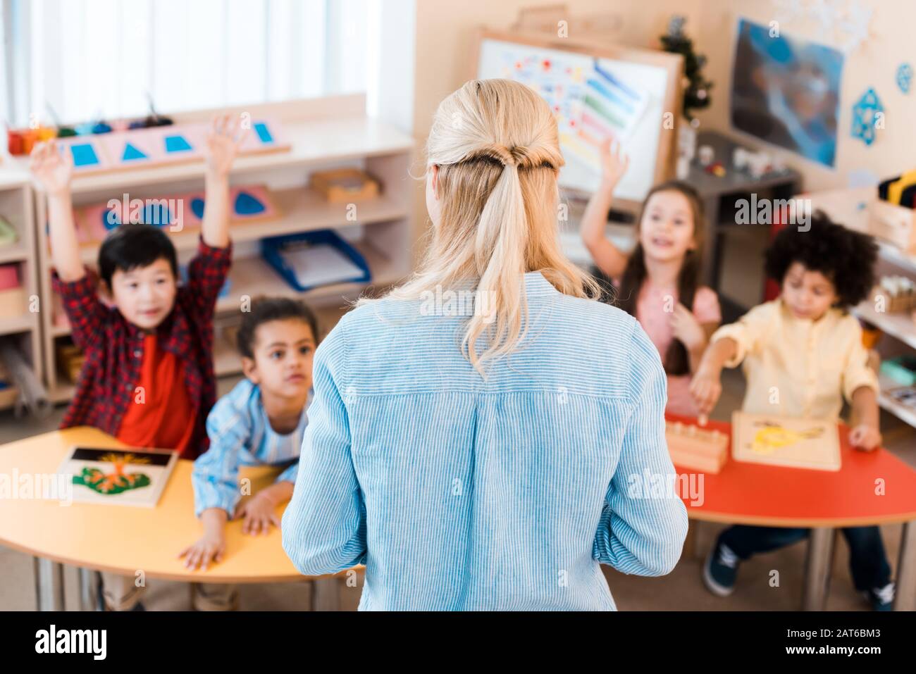 Selective focus of teacher conducting lesson with kids in montessori ...