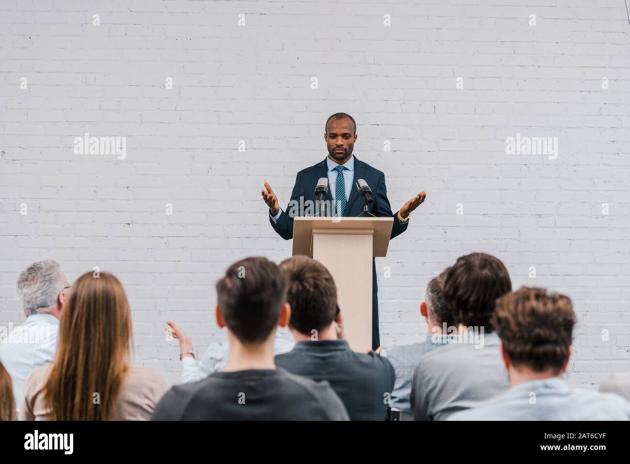 back view of journalists near handsome african american speaker talking ...