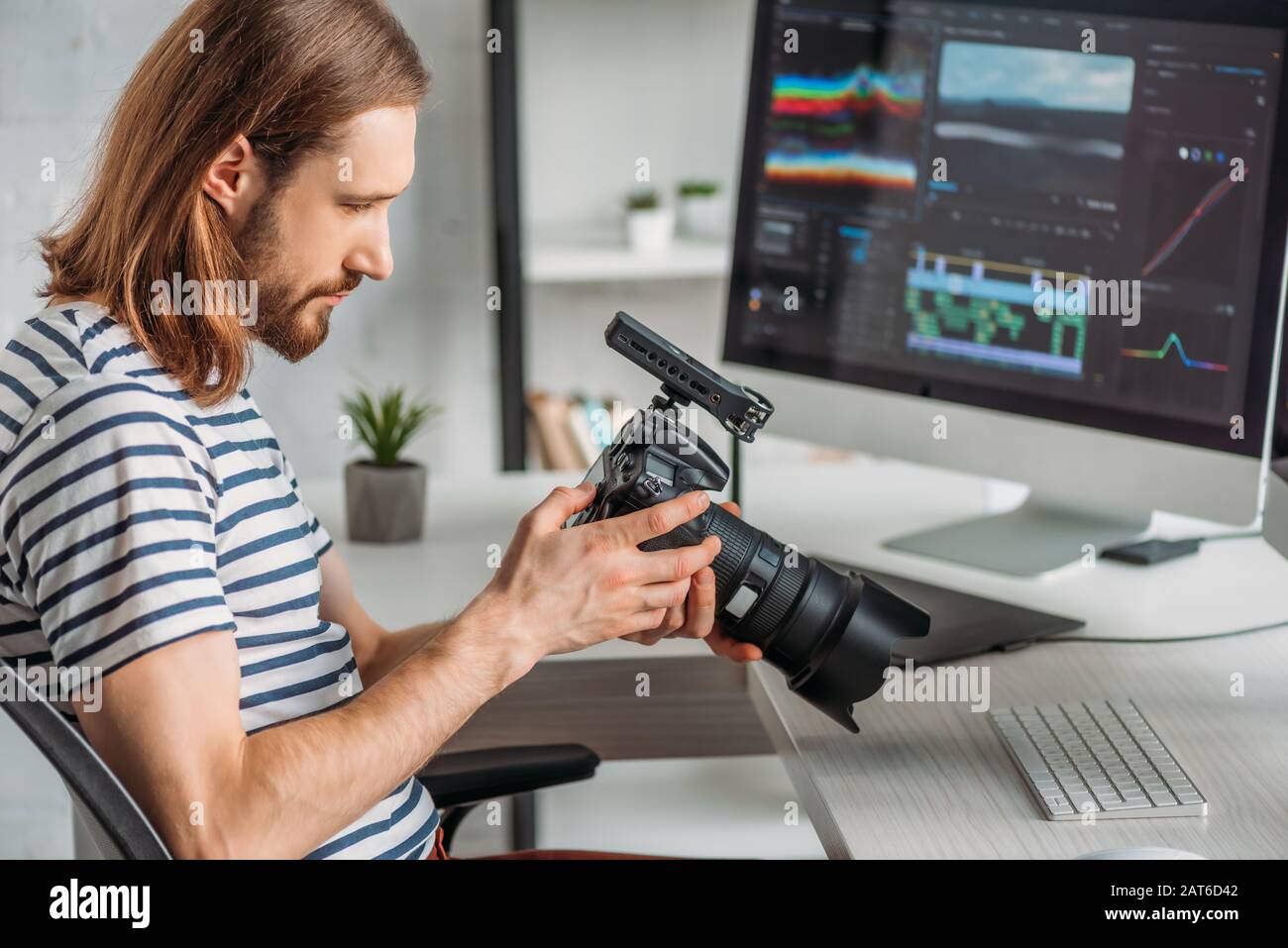 side view of editor holding digital camera Stock Photo - Alamy
