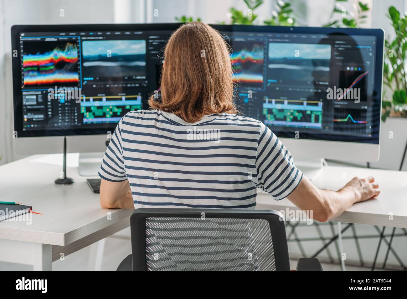 back view of editor working near computer monitors Stock Photo - Alamy