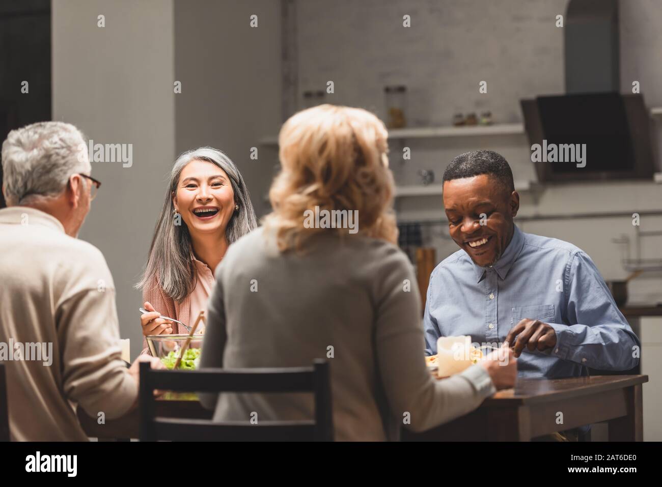 selective focus of smiling multicultural man and woman talking with ...