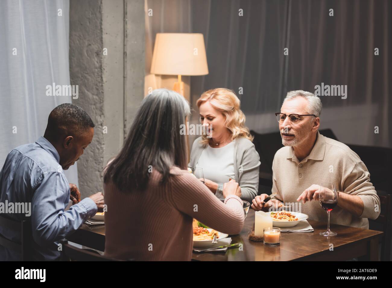 selective focus of smiling man and woman talking with multicultural ...