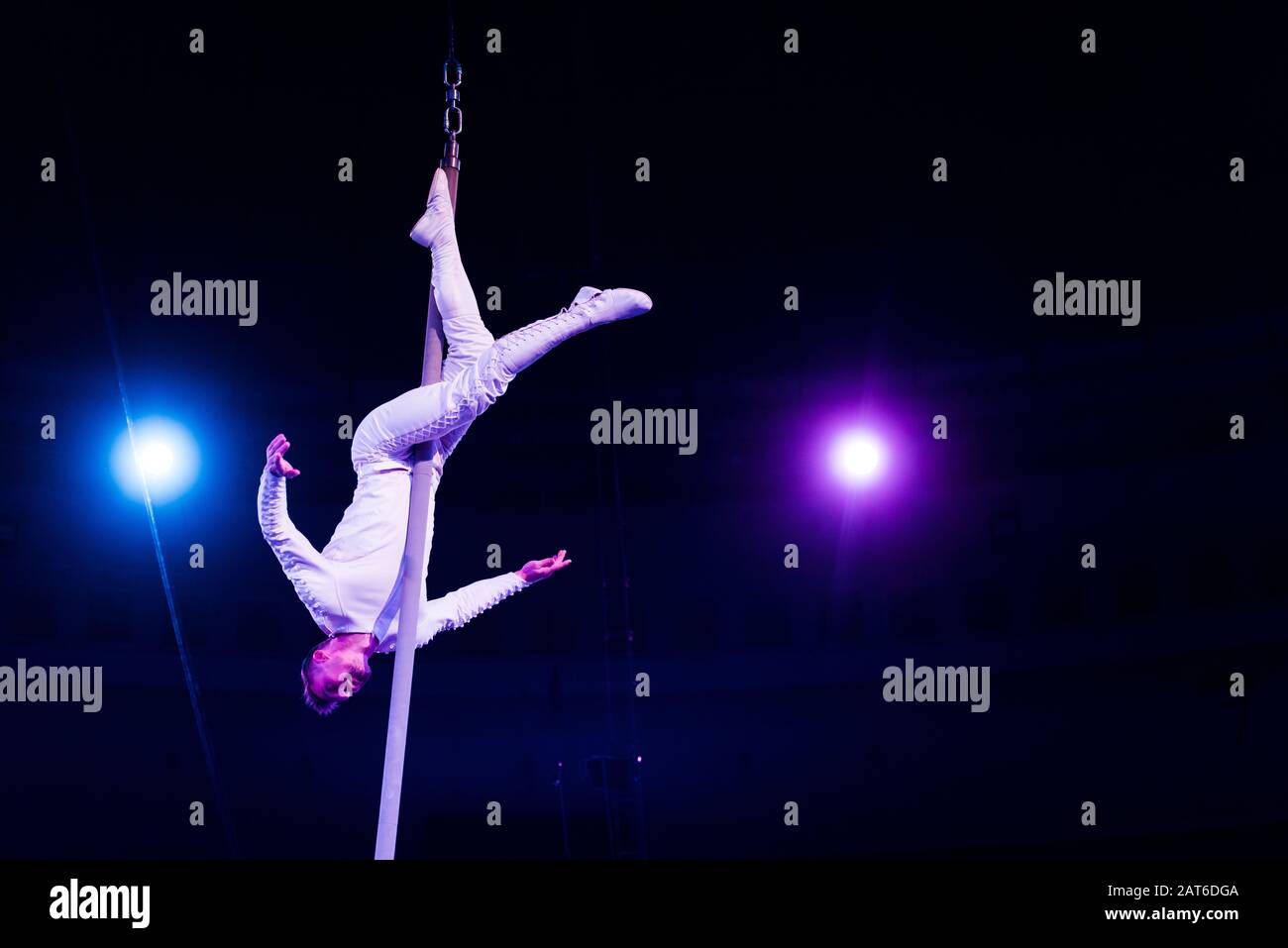 acrobat balancing on metallic pole in arena of circus Stock Photo - Alamy
