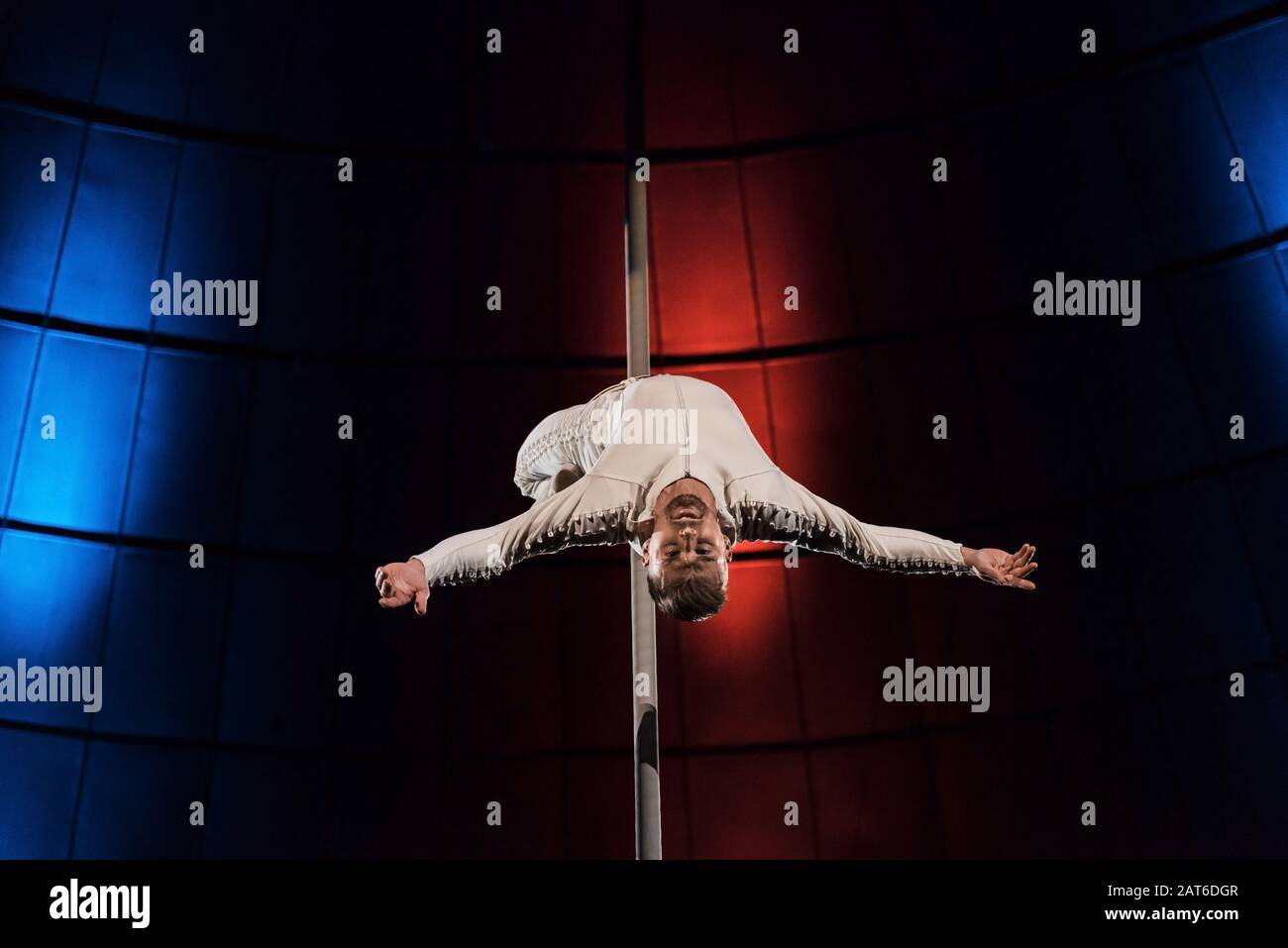 strong acrobat with outstretched hands looking at camera while ...