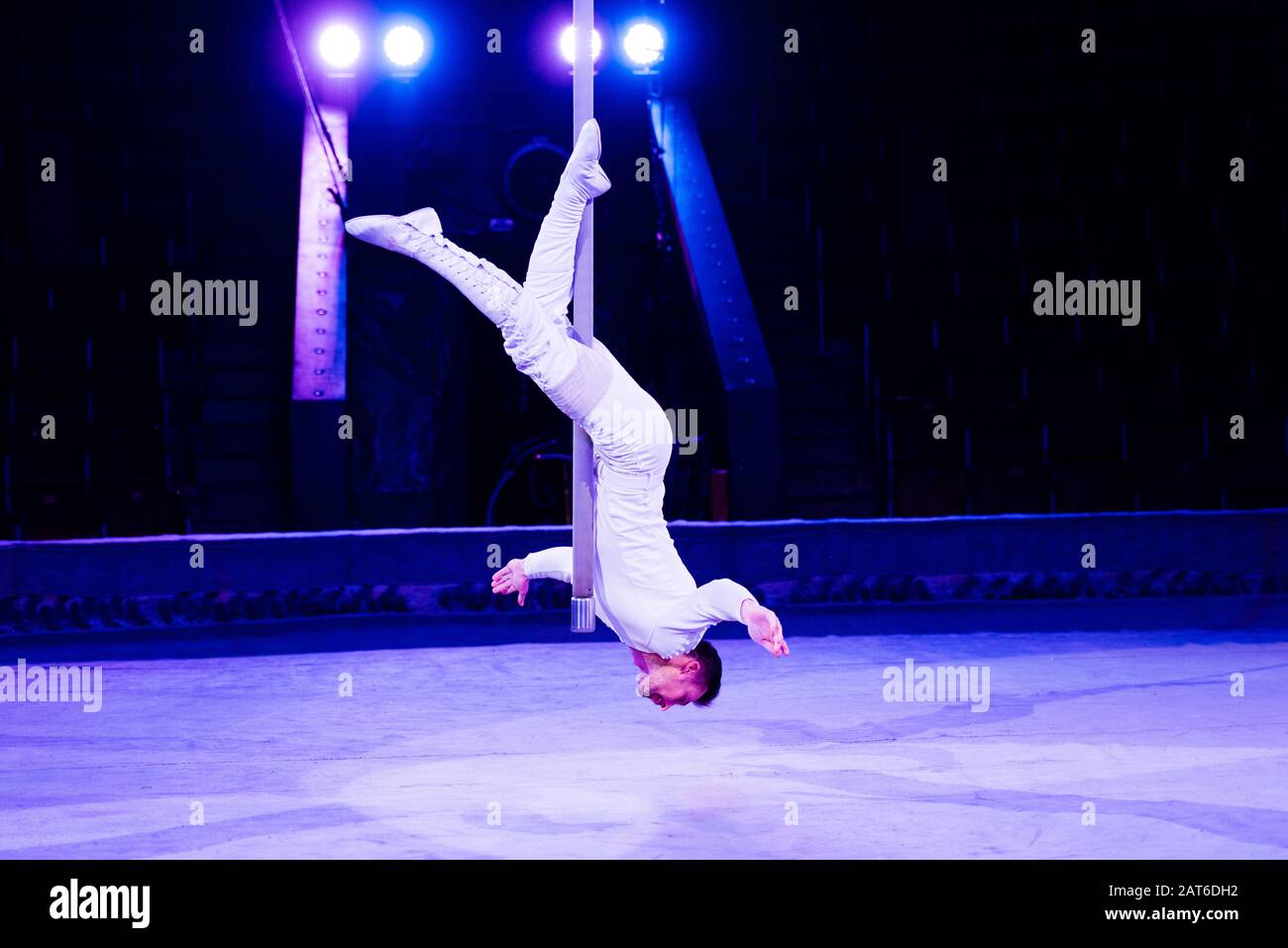 acrobat performing upside down on pole in arena of circus Stock Photo ...