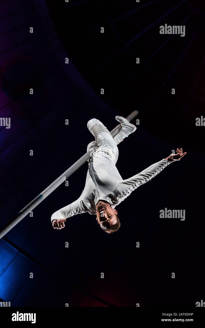 low angle view of acrobat posing while performing and looking at camera ...