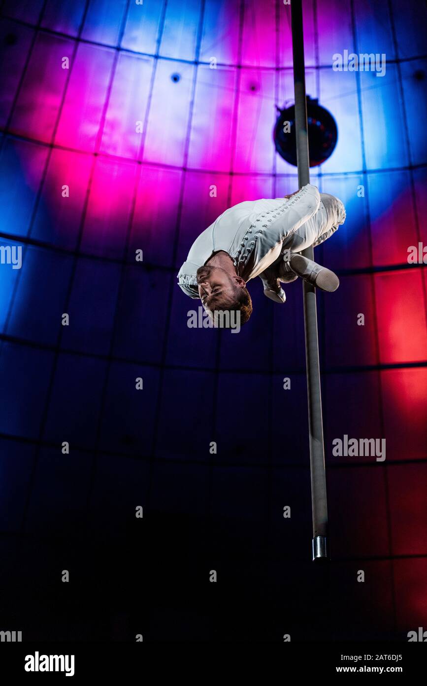 strong acrobat with closed eyes performing on metallic pole Stock Photo ...