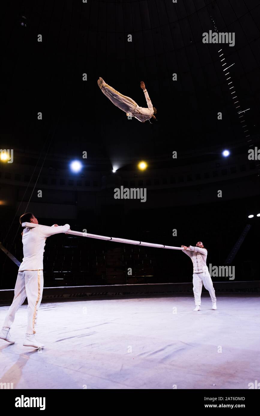 air acrobat jumping while performing near pole in circus Stock Photo ...