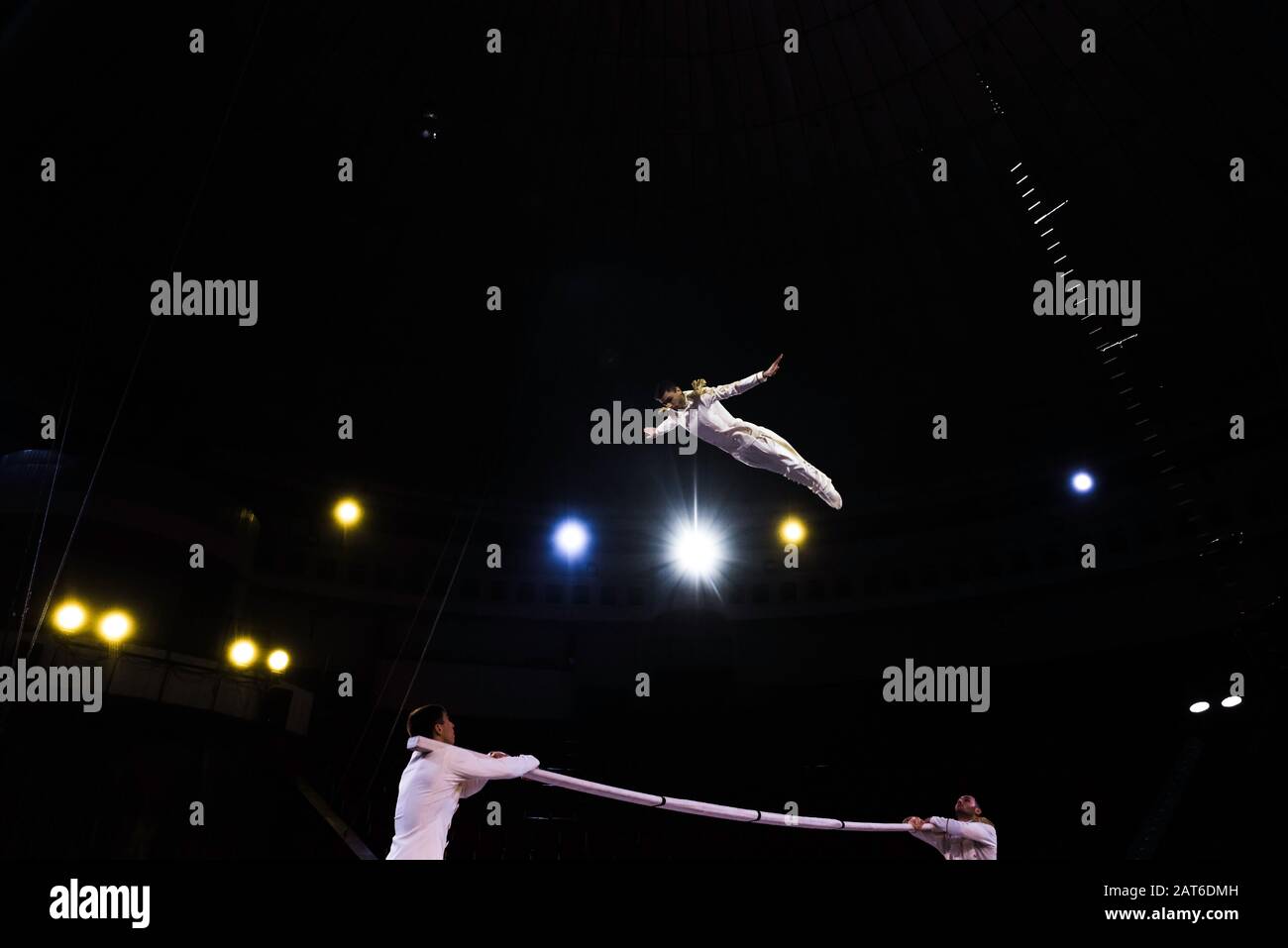 air acrobat jumping while performing near men in circus Stock Photo - Alamy