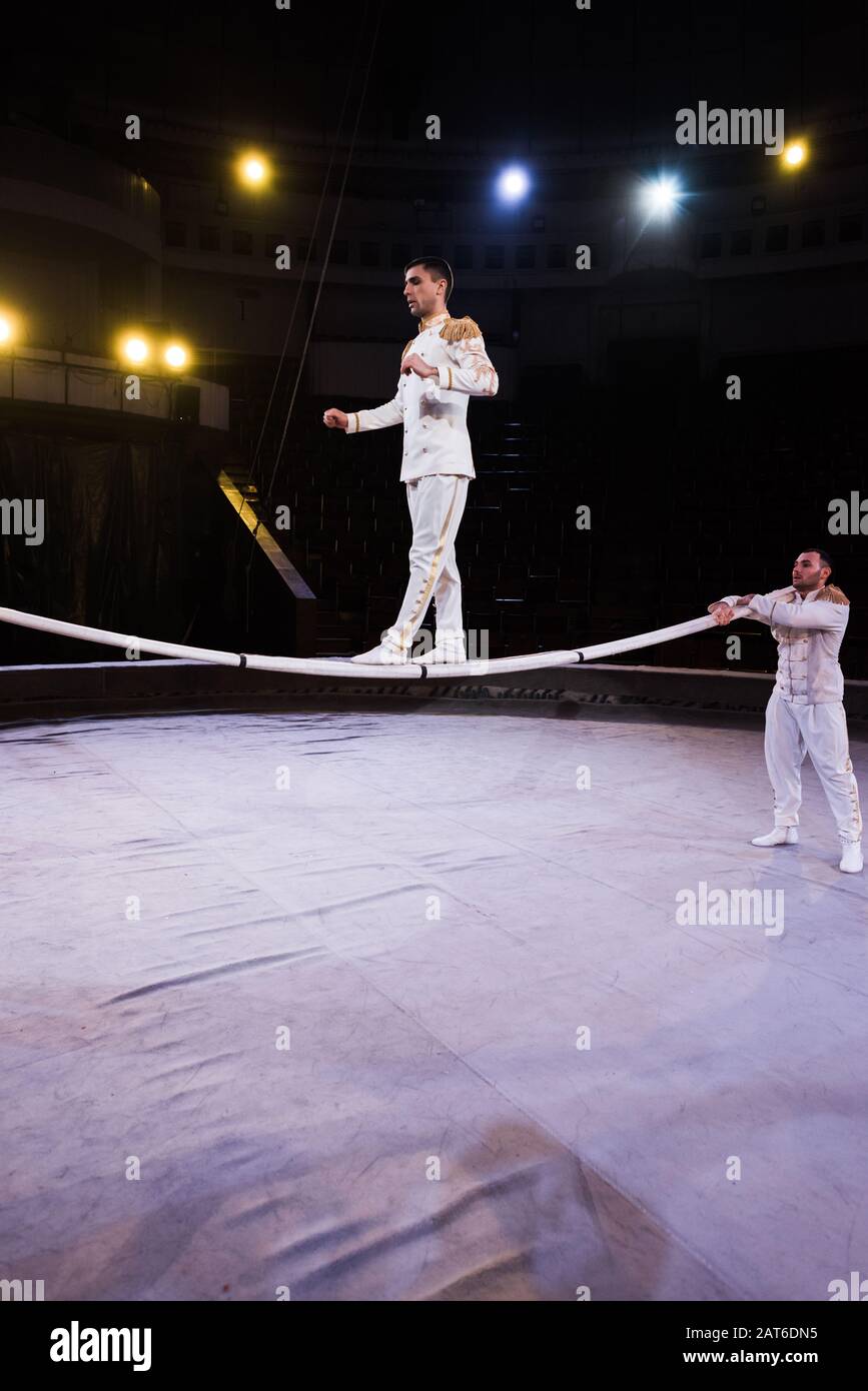 air acrobat balancing on pole near gymnast in circus Stock Photo - Alamy