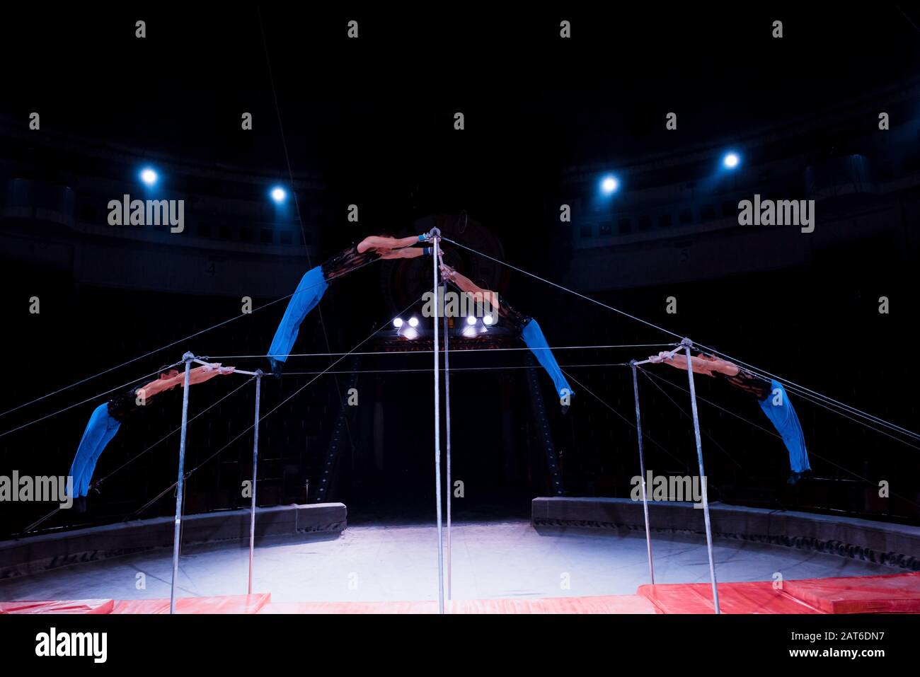 four gymnasts performing on horizontal bars in circus Stock Photo - Alamy