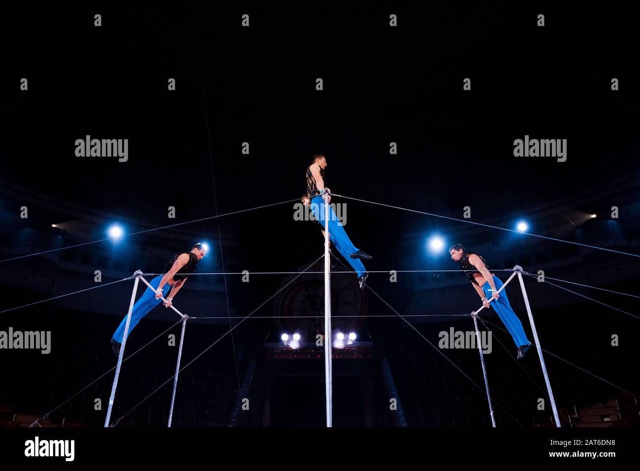 low angle view of gymnasts performing on horizontal bars in circus ...