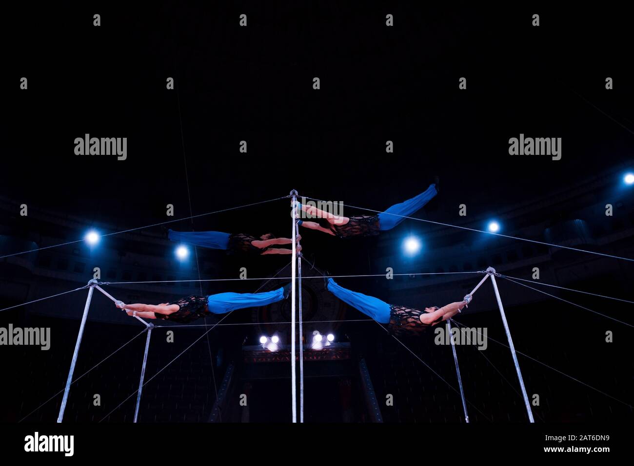 four acrobats performing on horizontal bars in circus Stock Photo - Alamy