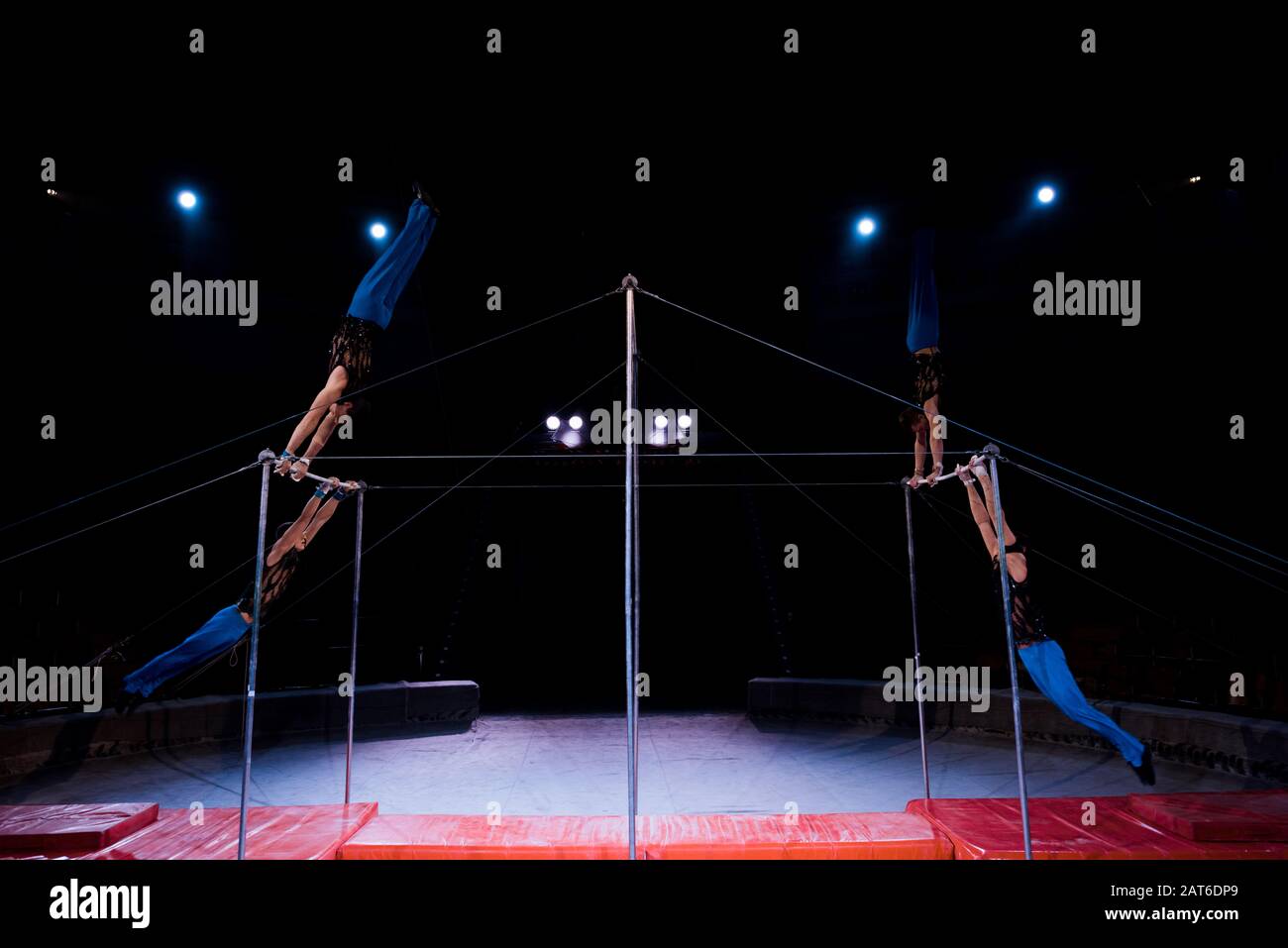 four gymnasts performing on horizontal bars in arena of circus Stock ...