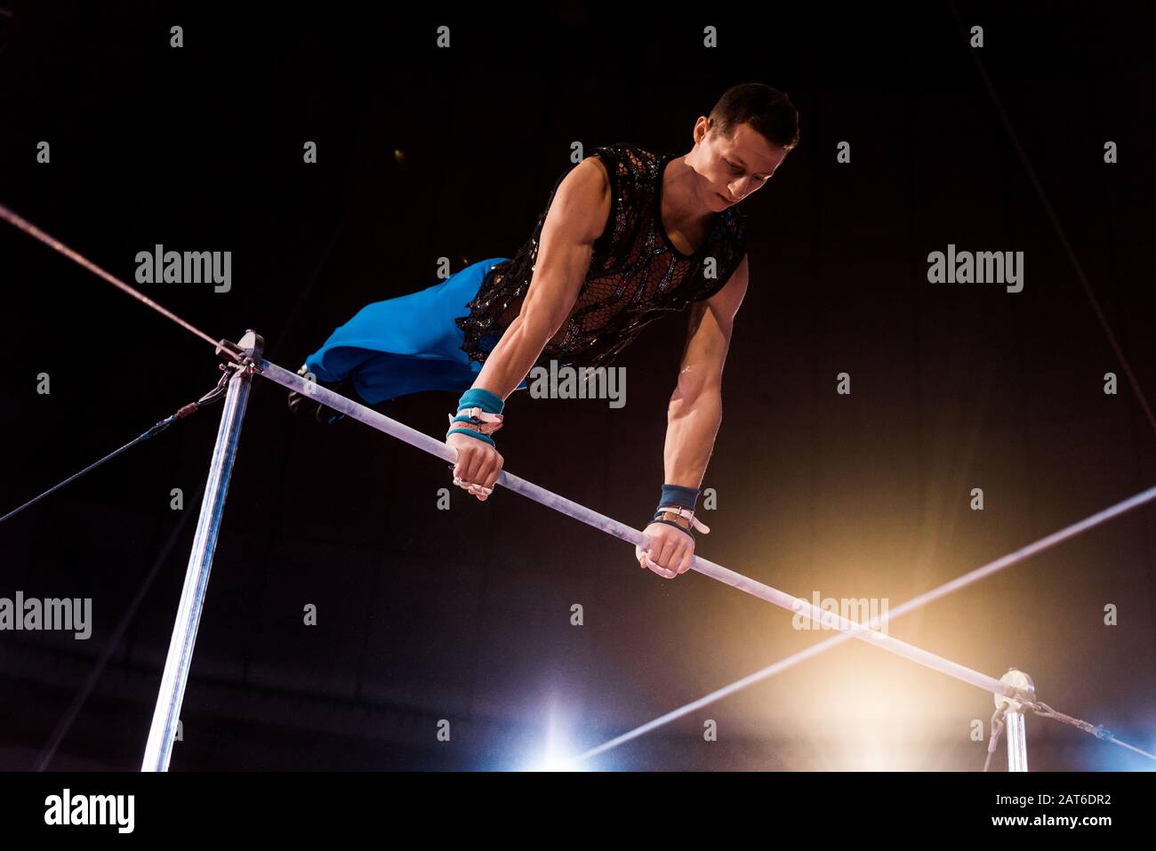 athletic gymnast performing on horizontal bars in arena of circus Stock ...