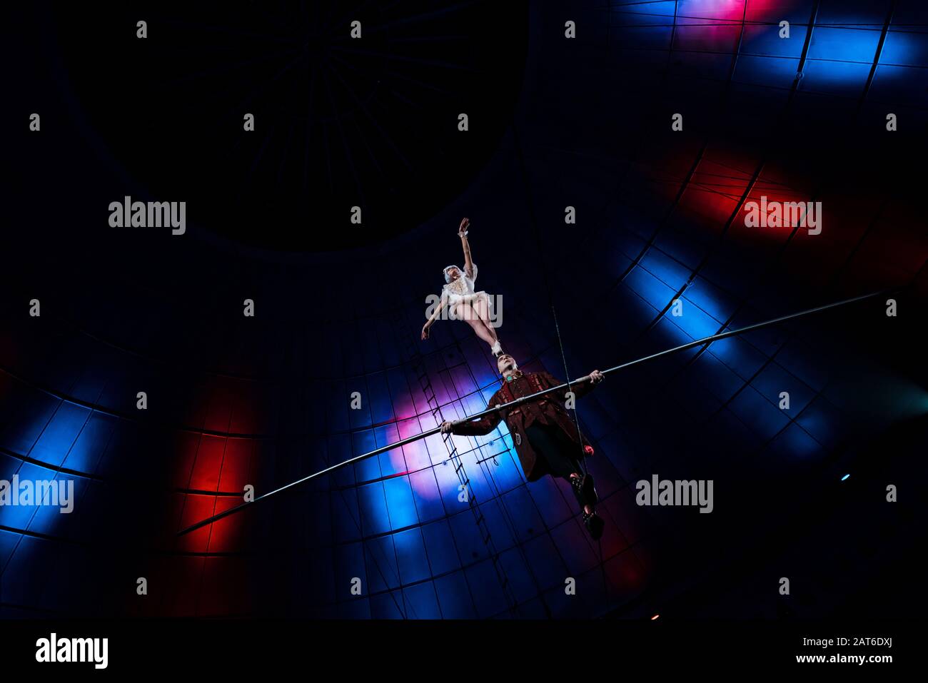 low angle view of handsome gymnast supporting attractive acrobat while ...