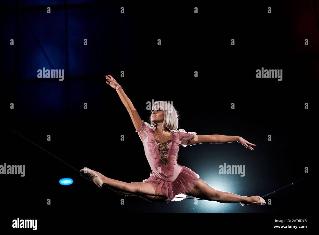 artistic aerial acrobat doing splits on rope while performing in circus ...
